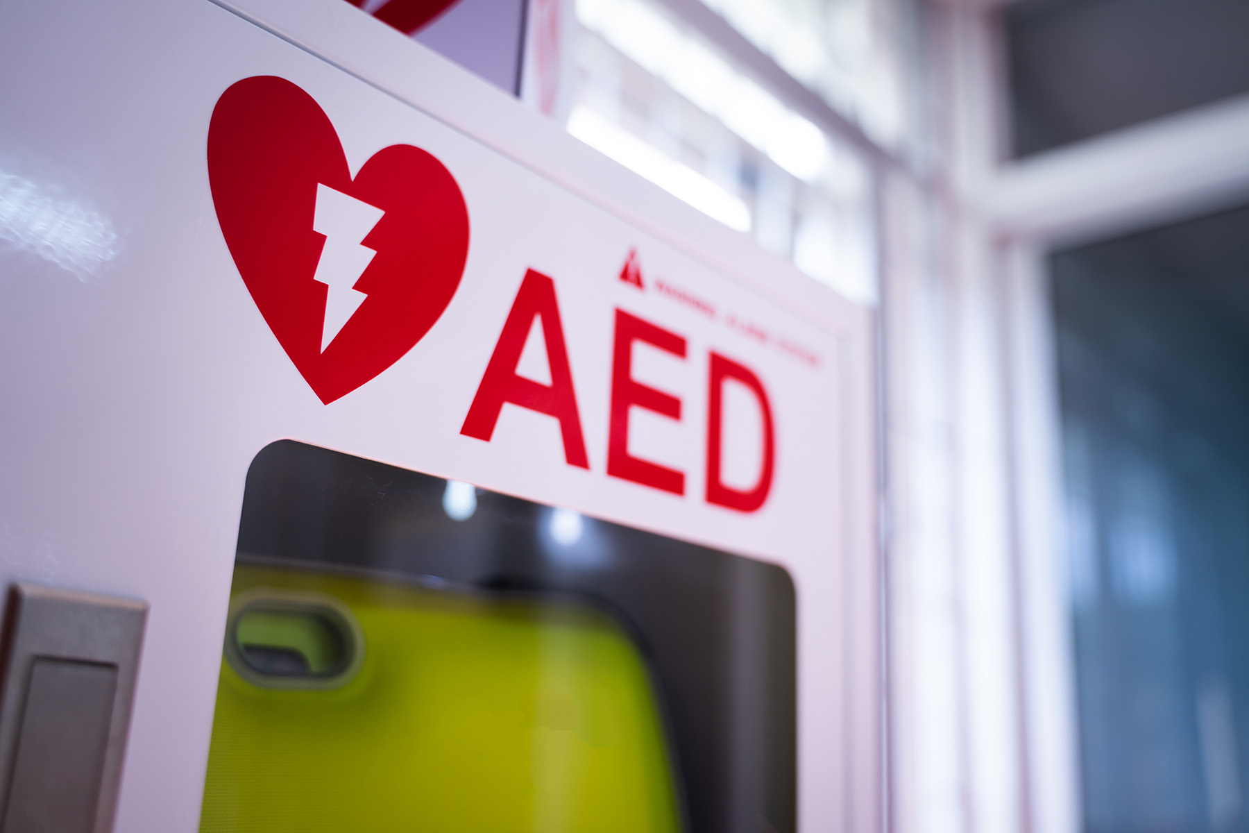 An automated external defibrillator (AED) in a white box is an e ...